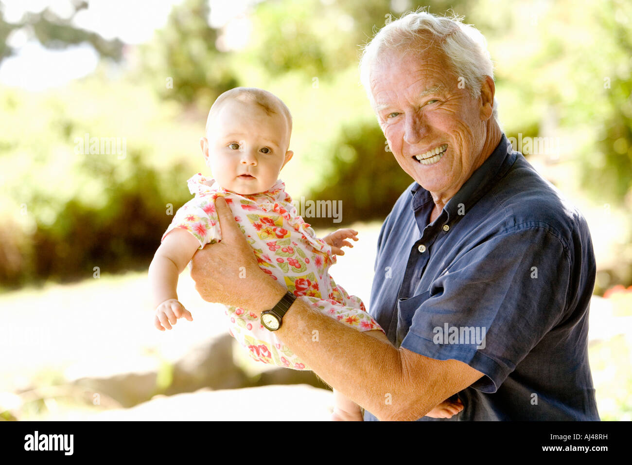 Senior man holding baby Stock Photo - Alamy