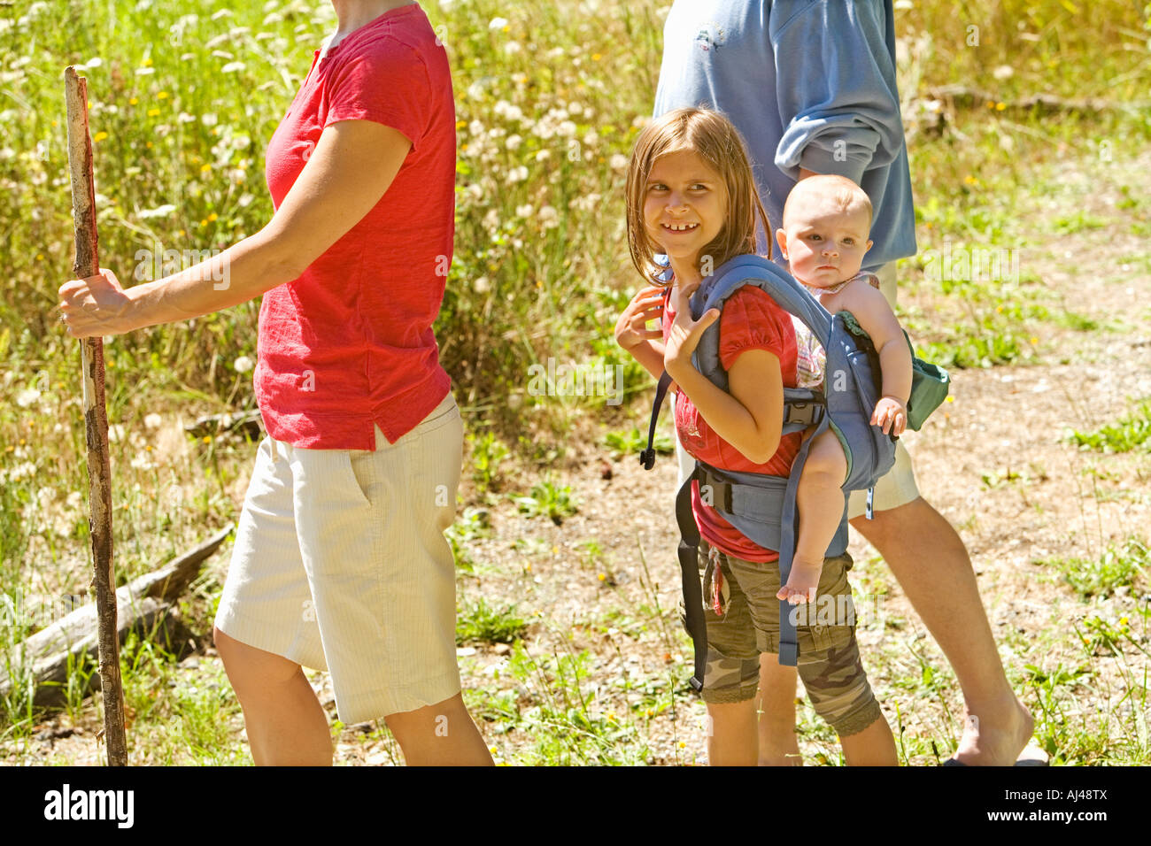 Girl carrying baby sibling on back Stock Photo - Alamy