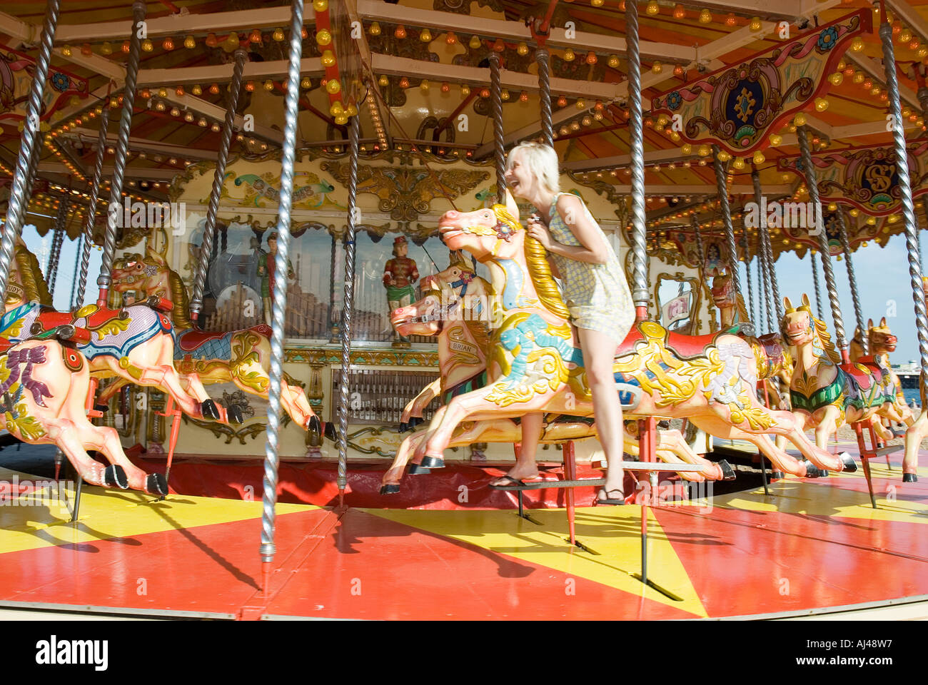 young woman riding a horse on a carousel Stock Photo - Alamy