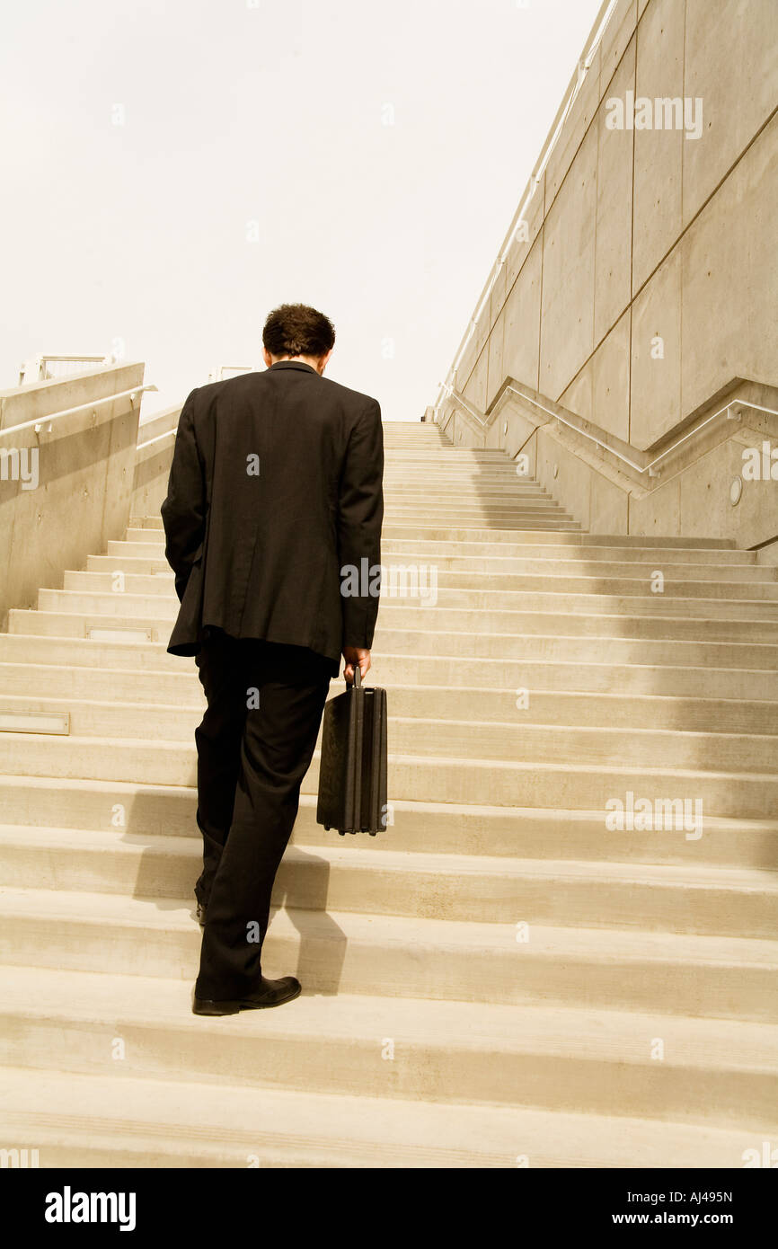 Businessman walking up steps Stock Photo - Alamy