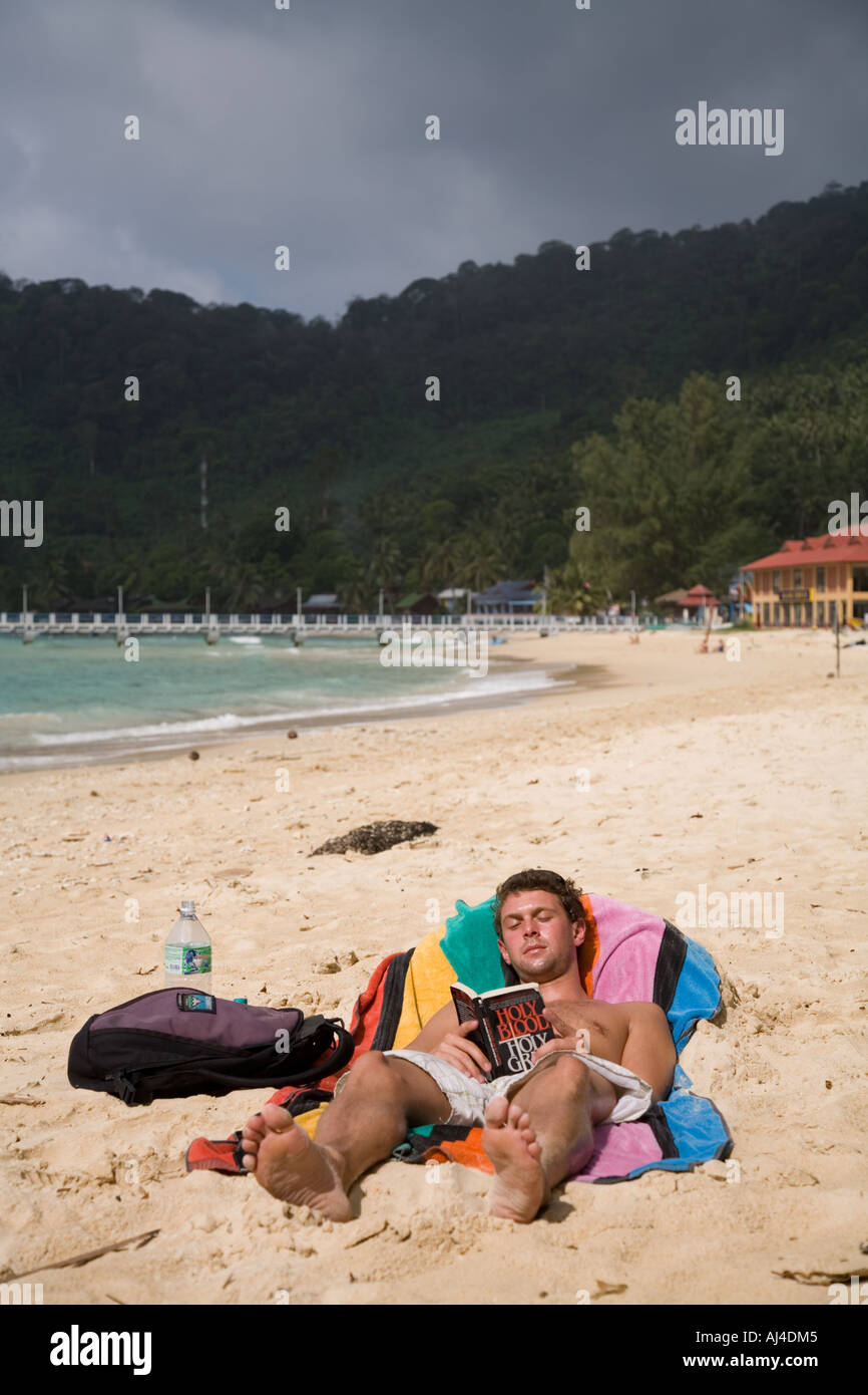 Tourist reading a book on the beach at Salang Tioman. Tioman Island ...