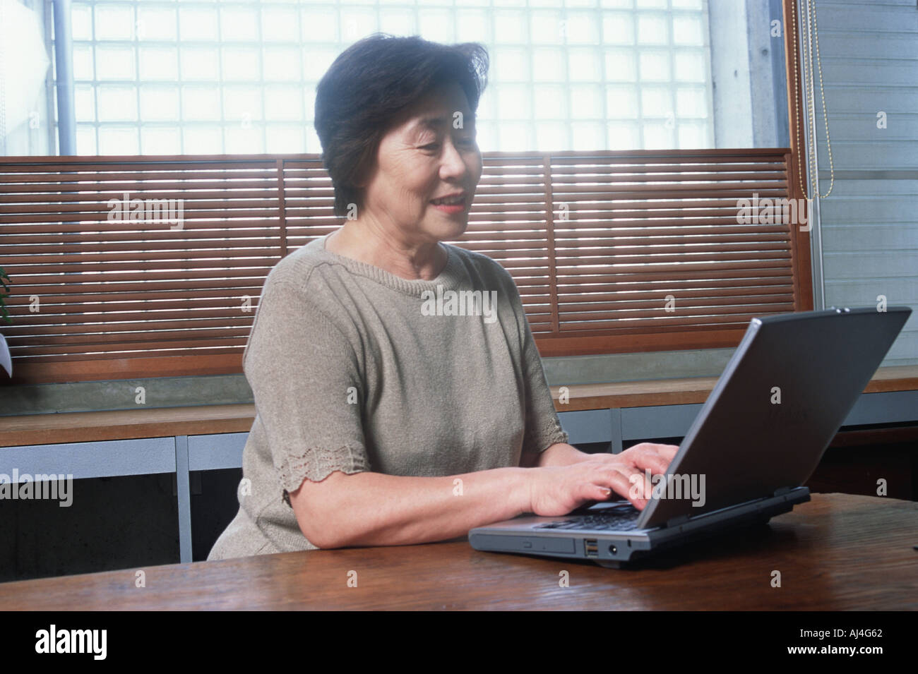 Asian senior woman typing hi-res stock photography and images - Alamy