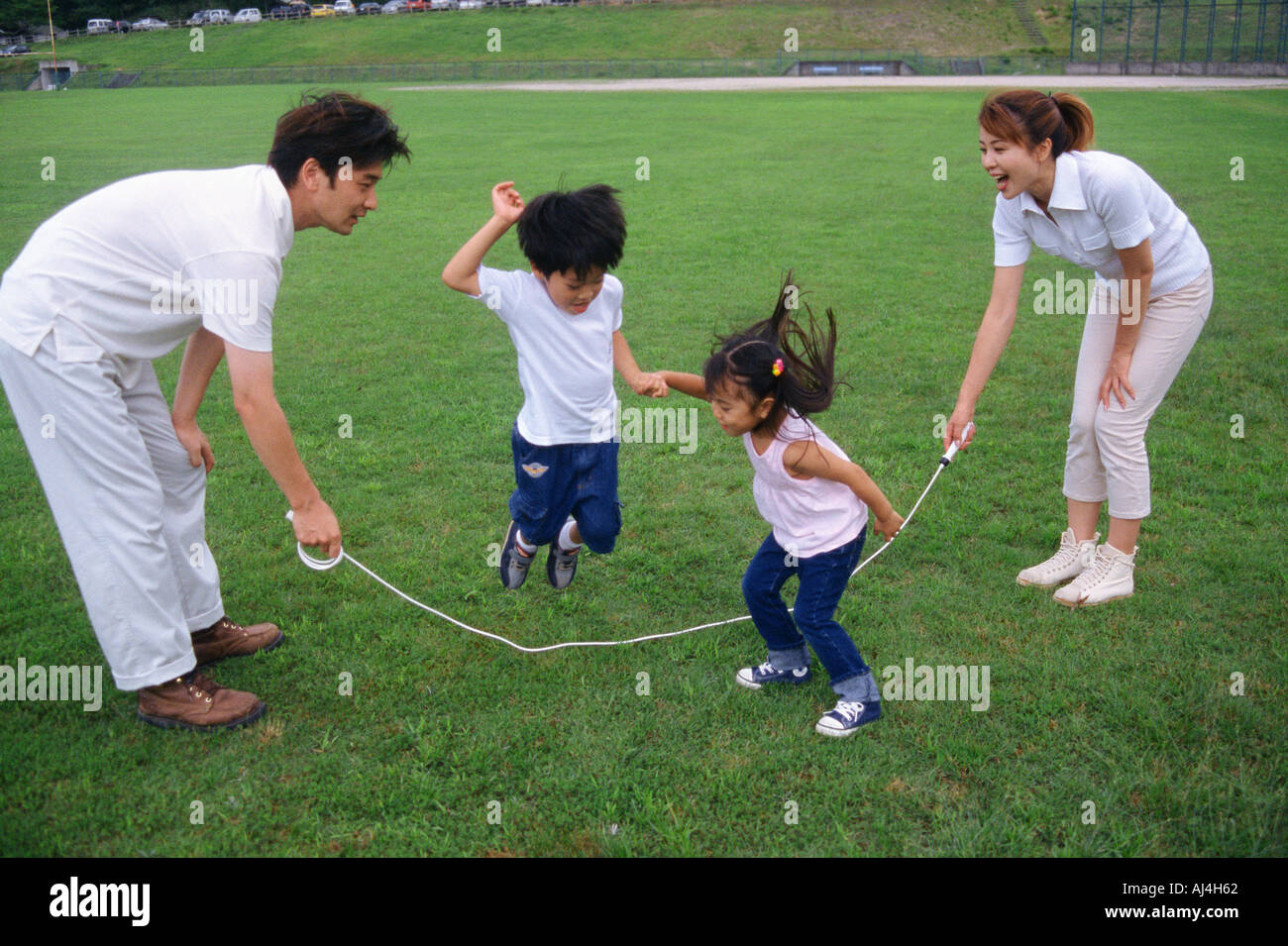 Family playing with jump rope Stock Photo - Alamy