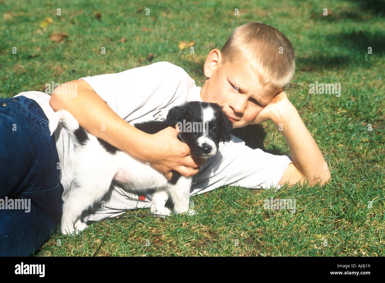 a young boy cuddling his puppy Stock Photo - Alamy