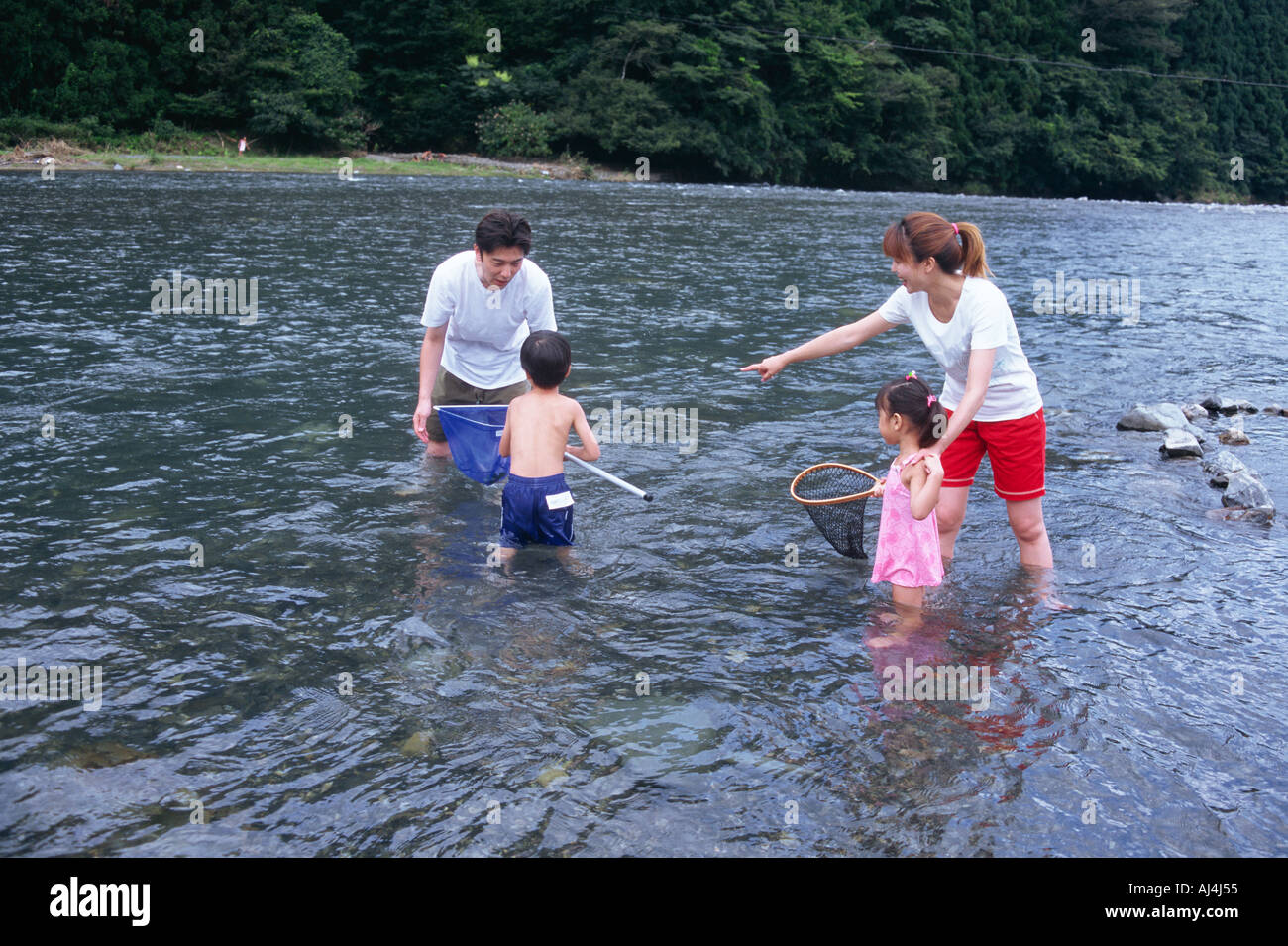 Family playing in river Stock Photo - Alamy
