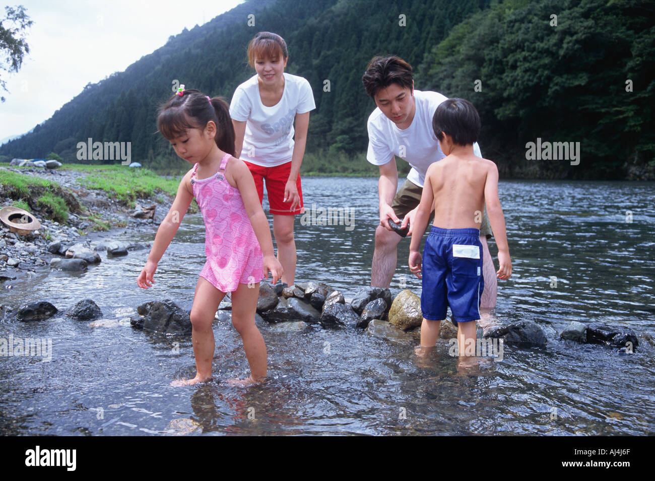 Family playing in a river Stock Photo - Alamy