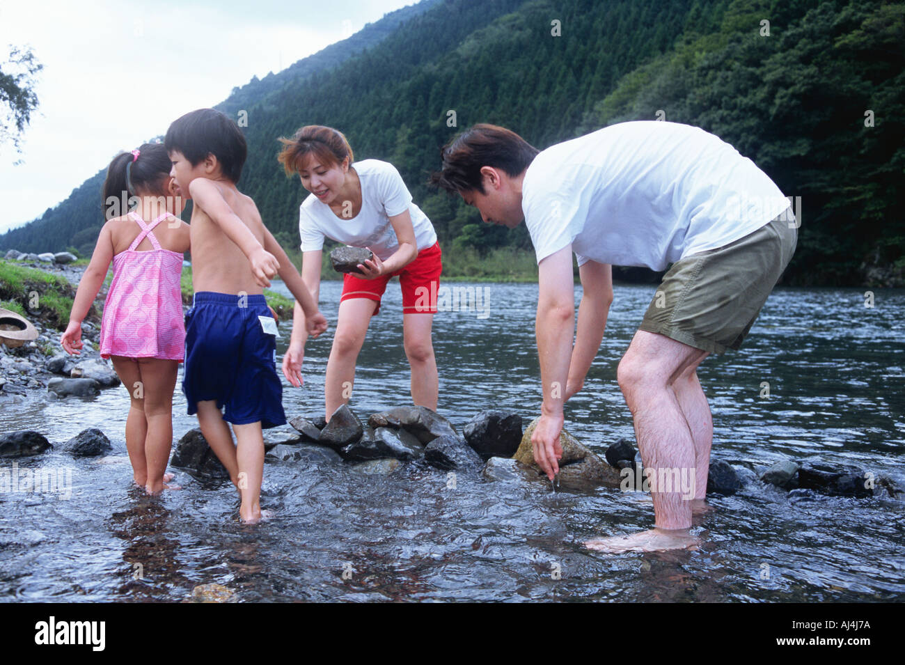 Family playing in a river Stock Photo - Alamy