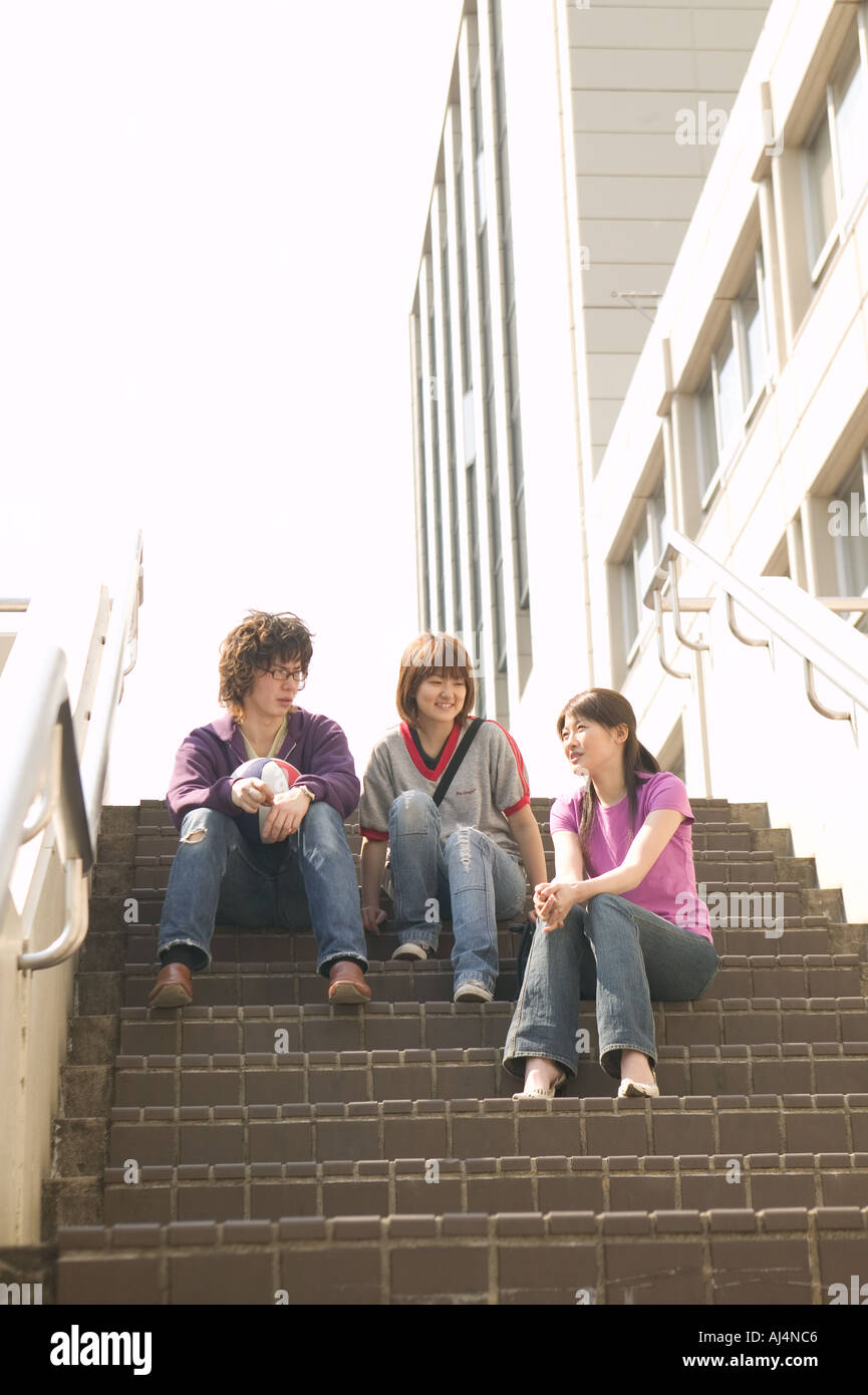 Three college students talking Stock Photo - Alamy