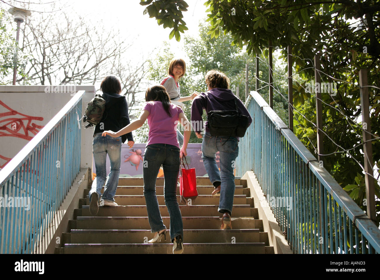 Four college students walking up stairs Stock Photo - Alamy