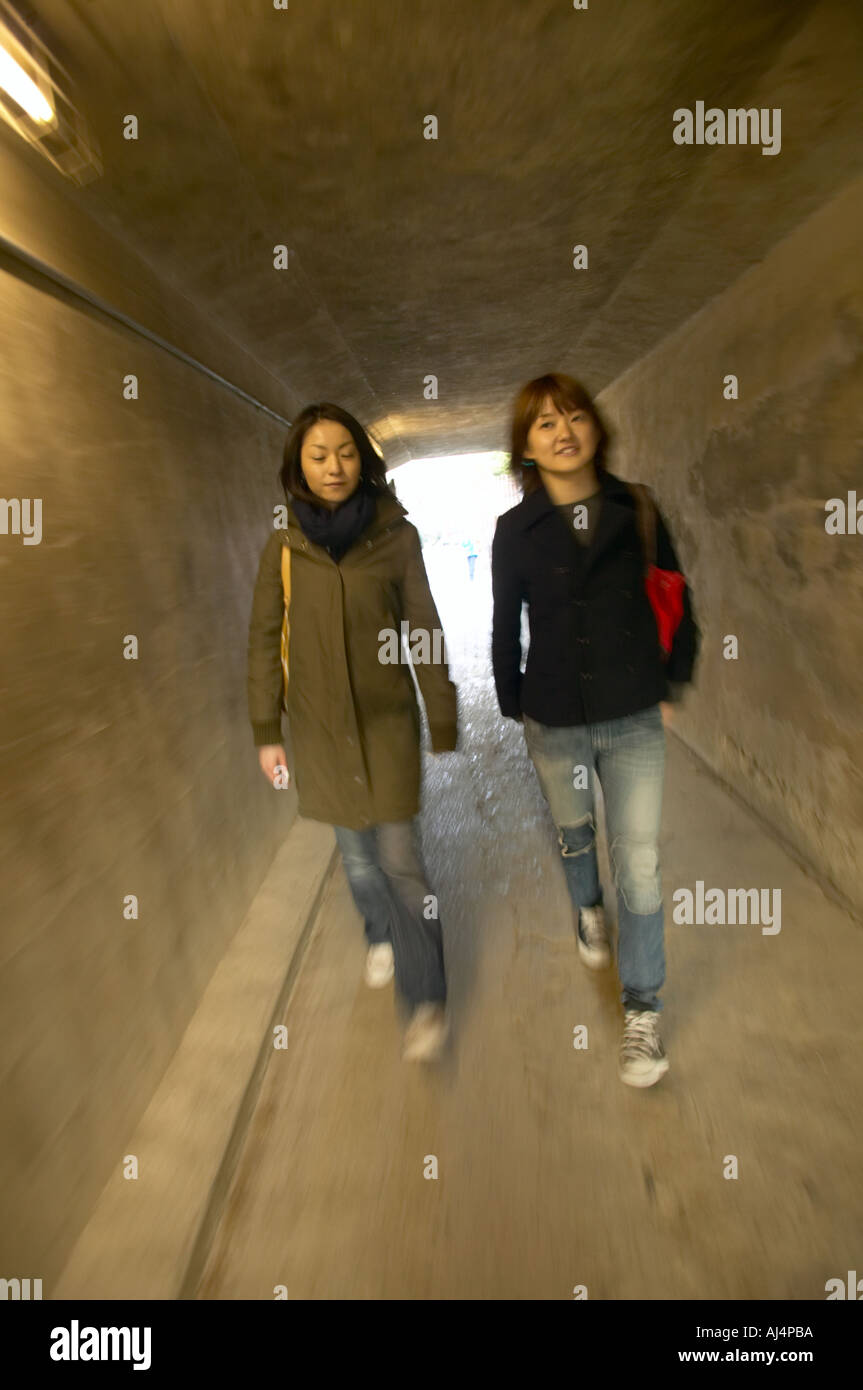 Two college students walking down corridor blurred motion Stock Photo ...