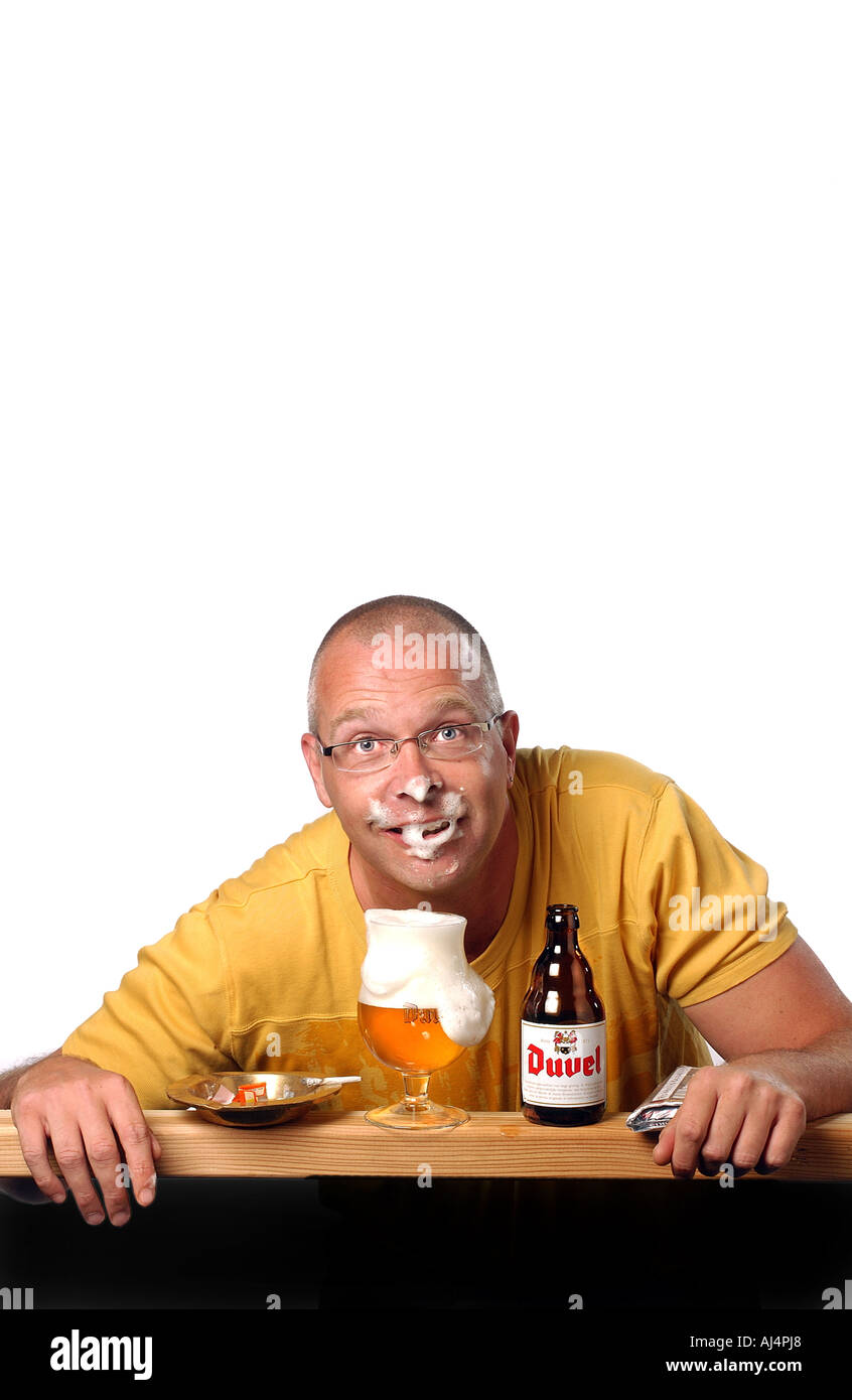 Bald man in a bar drinking a cold belgian duvel beer, showing foam ...
