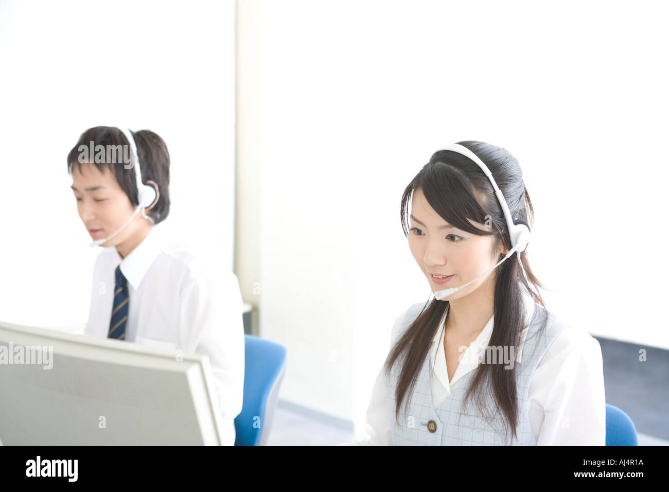 Two young adults wearing headsets Stock Photo - Alamy