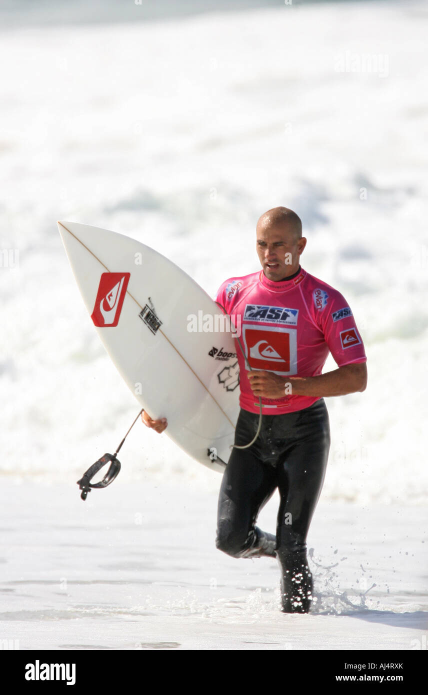 Pro Surfer Kelly Slater leaves the sea with his Surfboard Stock Photo ...