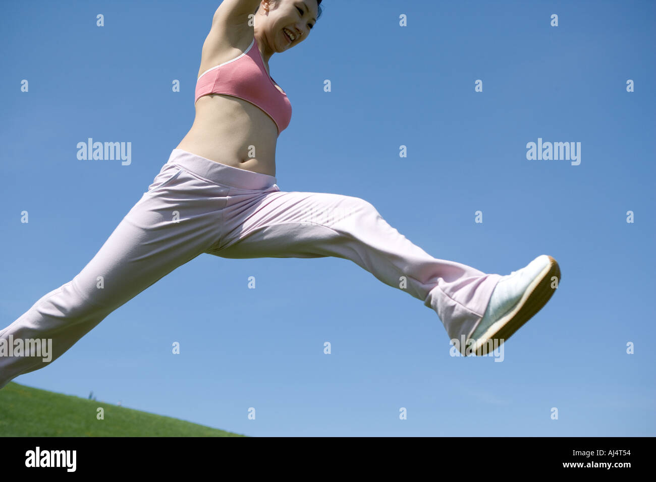 Woman leaping grass hi-res stock photography and images - Alamy
