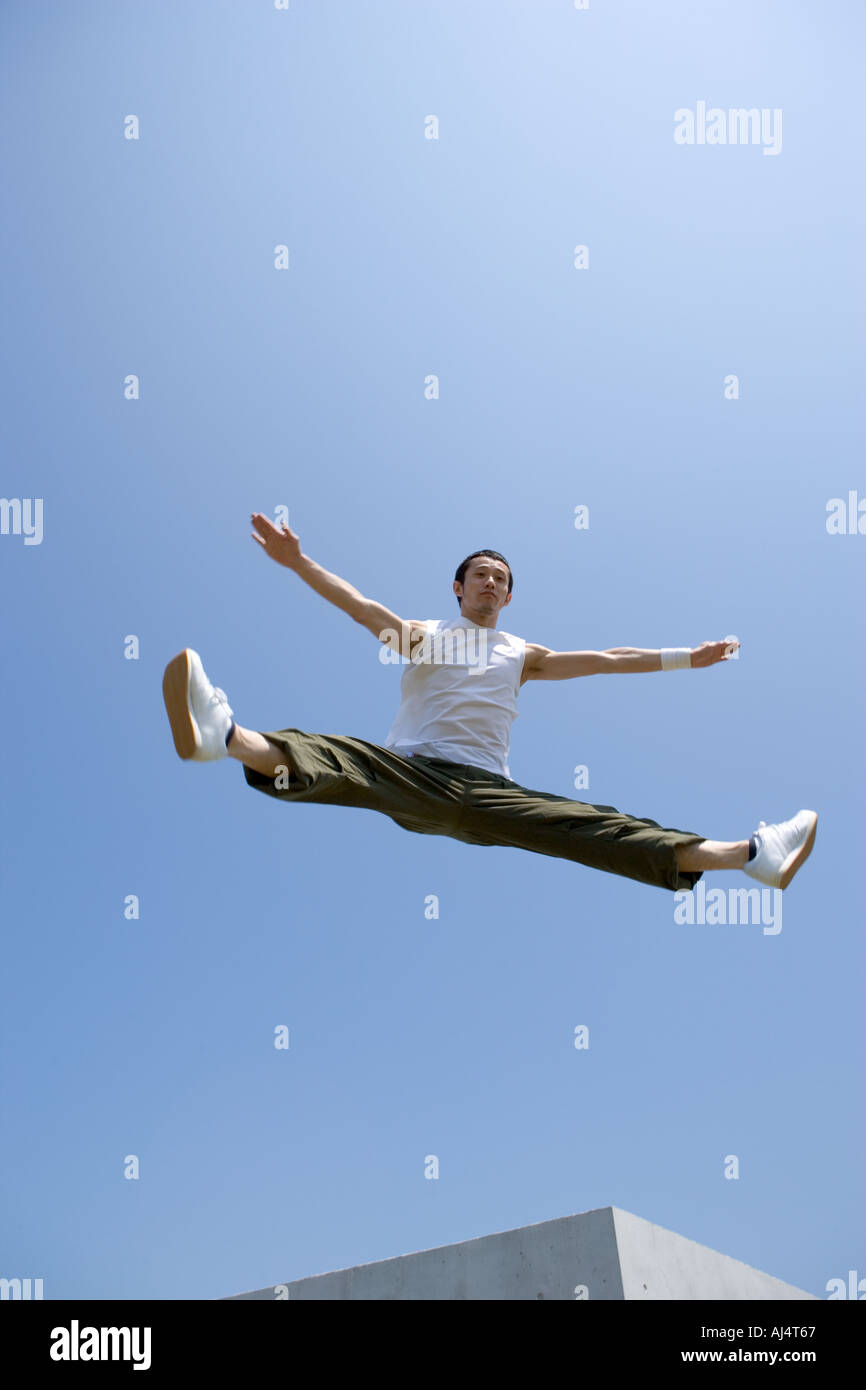 Young man jumping and doing splits in mid air Stock Photo - Alamy