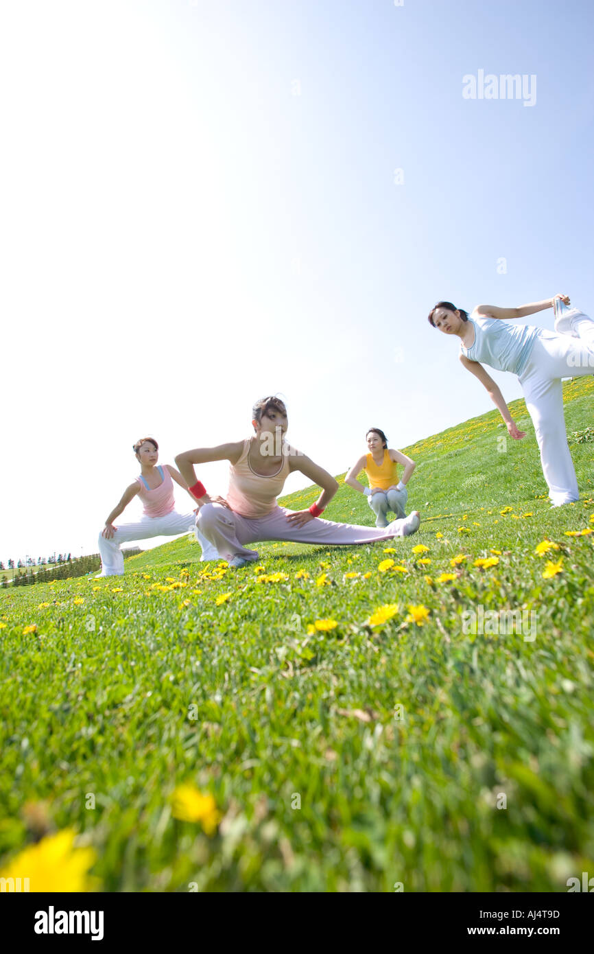 Four young Woman stretching in field Stock Photo - Alamy