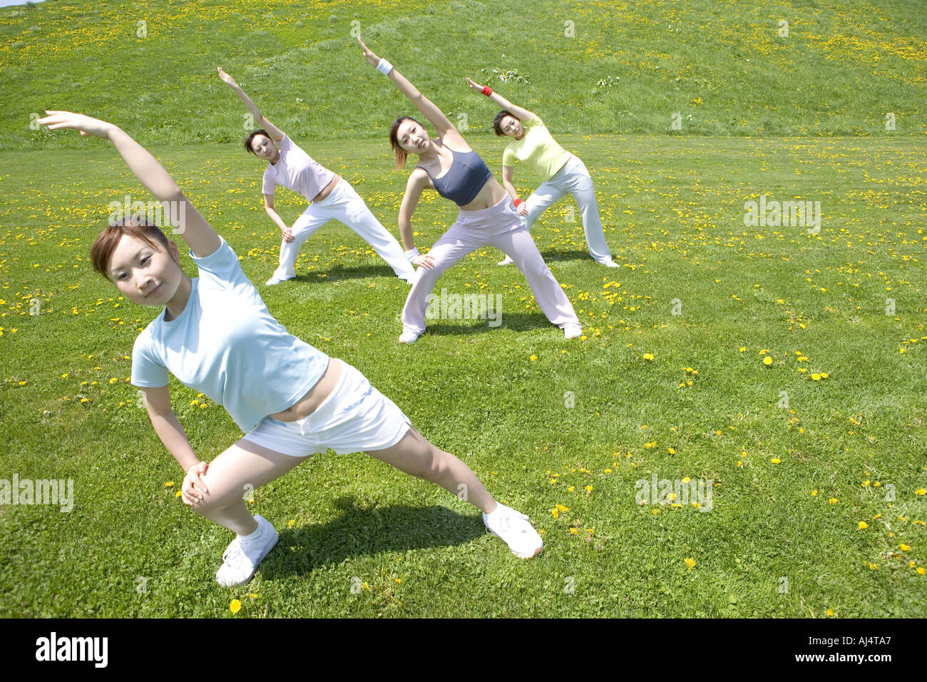 Four young Woman stretching in field Stock Photo - Alamy