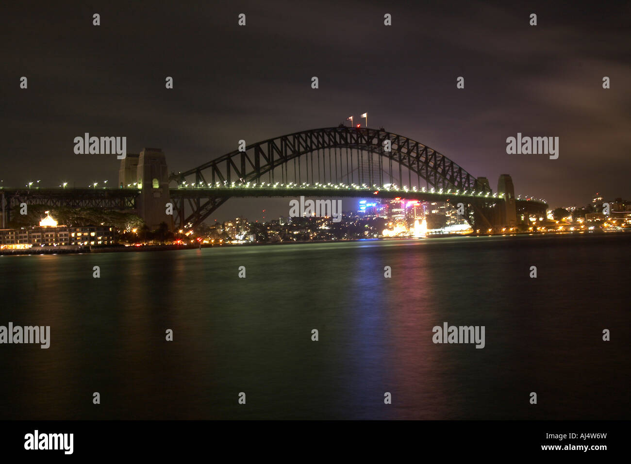 Harbour Bridge with reflections in harbour water at night in Sydney New ...