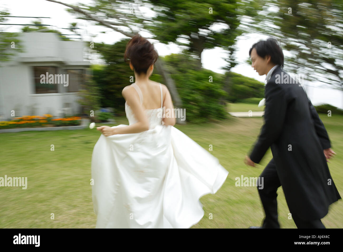 Bride and groom running on lawn blurred motion Stock Photo - Alamy