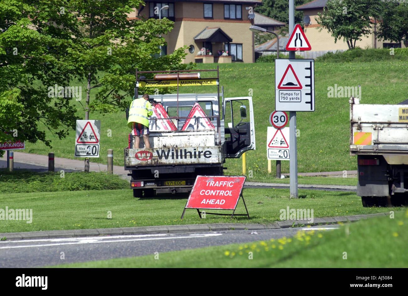 Workman set out traffic control signs UK Stock Photo - Alamy