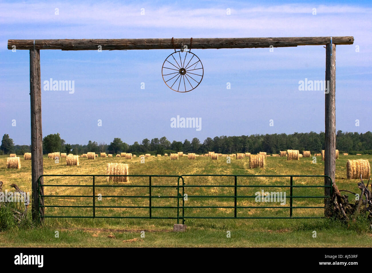 Rolled Haybales behind a Wagon Wheel Gate Stock Photo - Alamy
