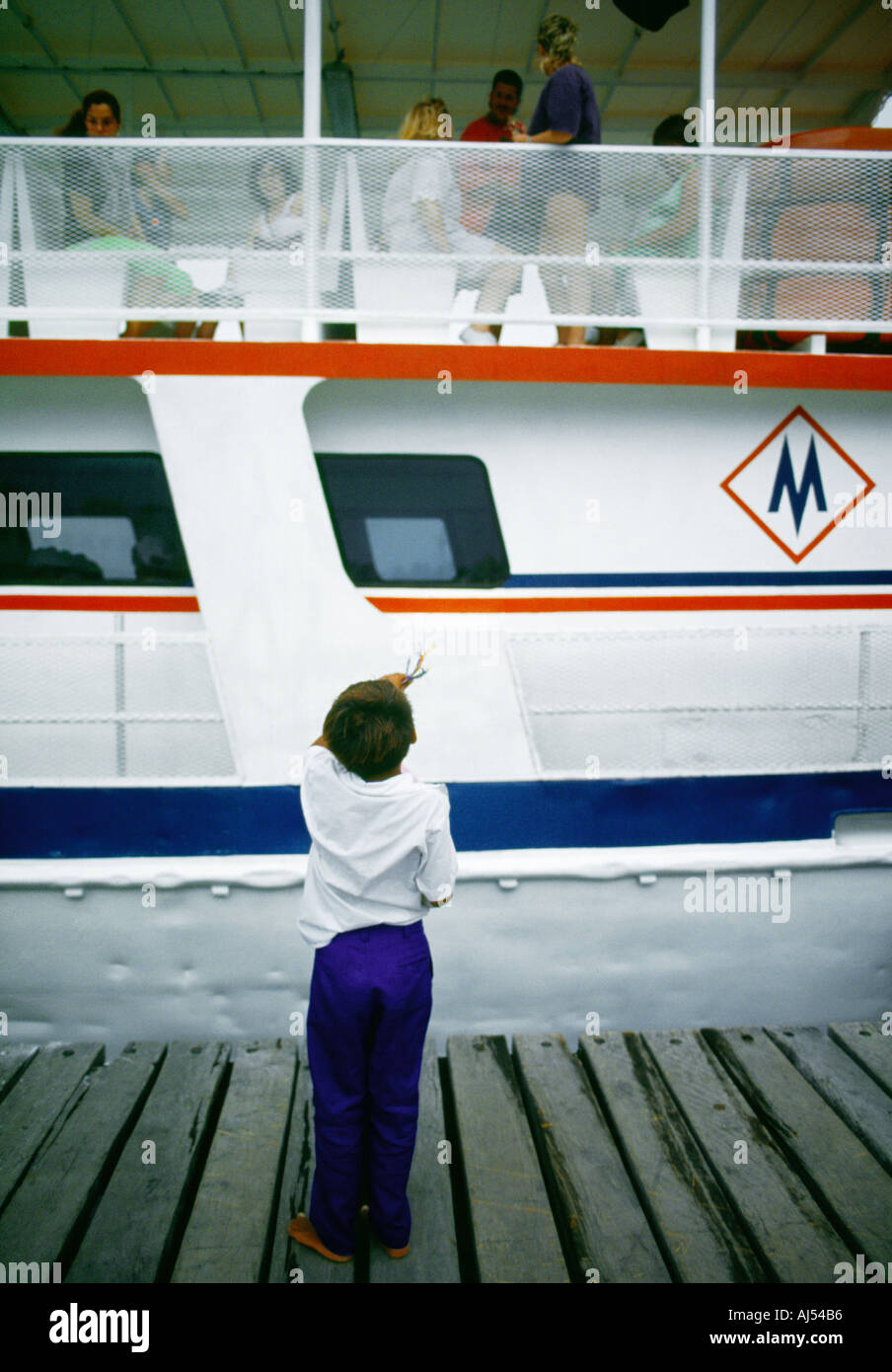A young boy waves goodbye to a holiday ferry boat Stock Photo - Alamy