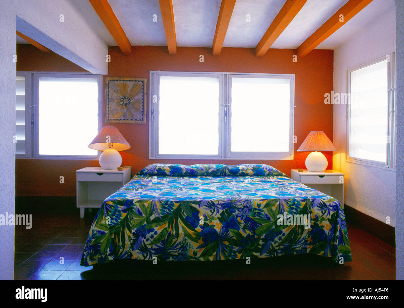 A bright hotel room with a large double bed and beamed ceiling Stock ...