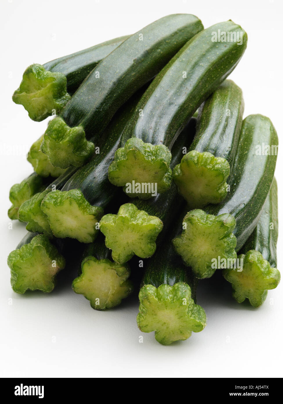 A stack of baby courgettes on a white background Stock Photo - Alamy