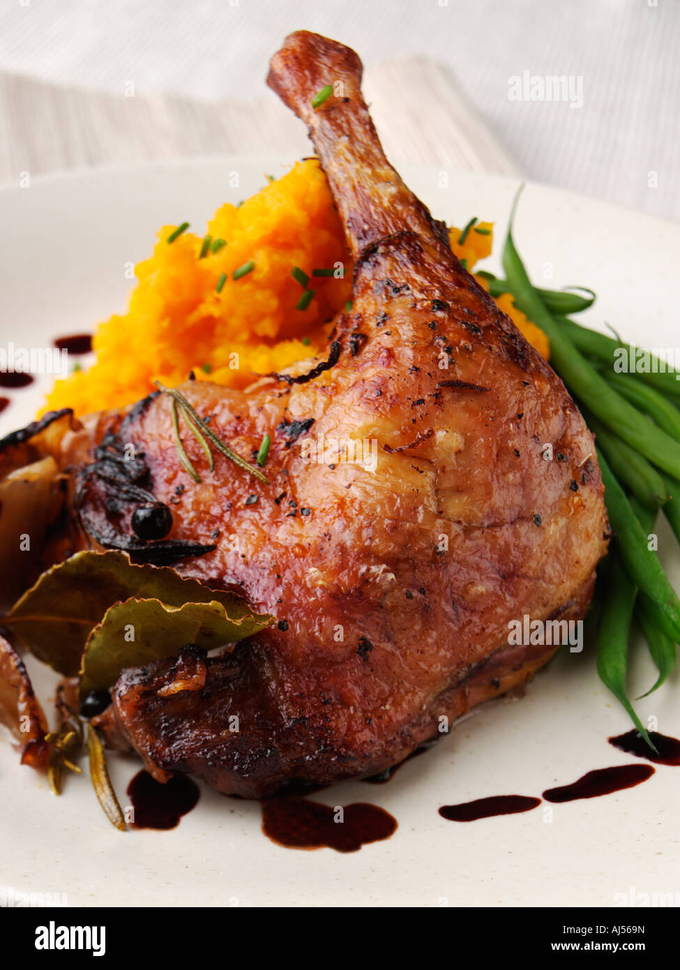 Roast duck leg with mashed swede and French beans Stock Photo - Alamy