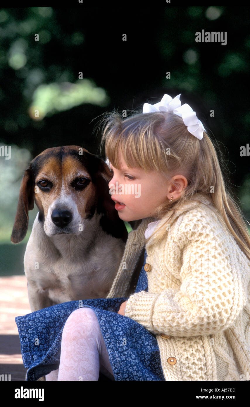 Little girl talking and hugging Beagle dog Stock Photo - Alamy