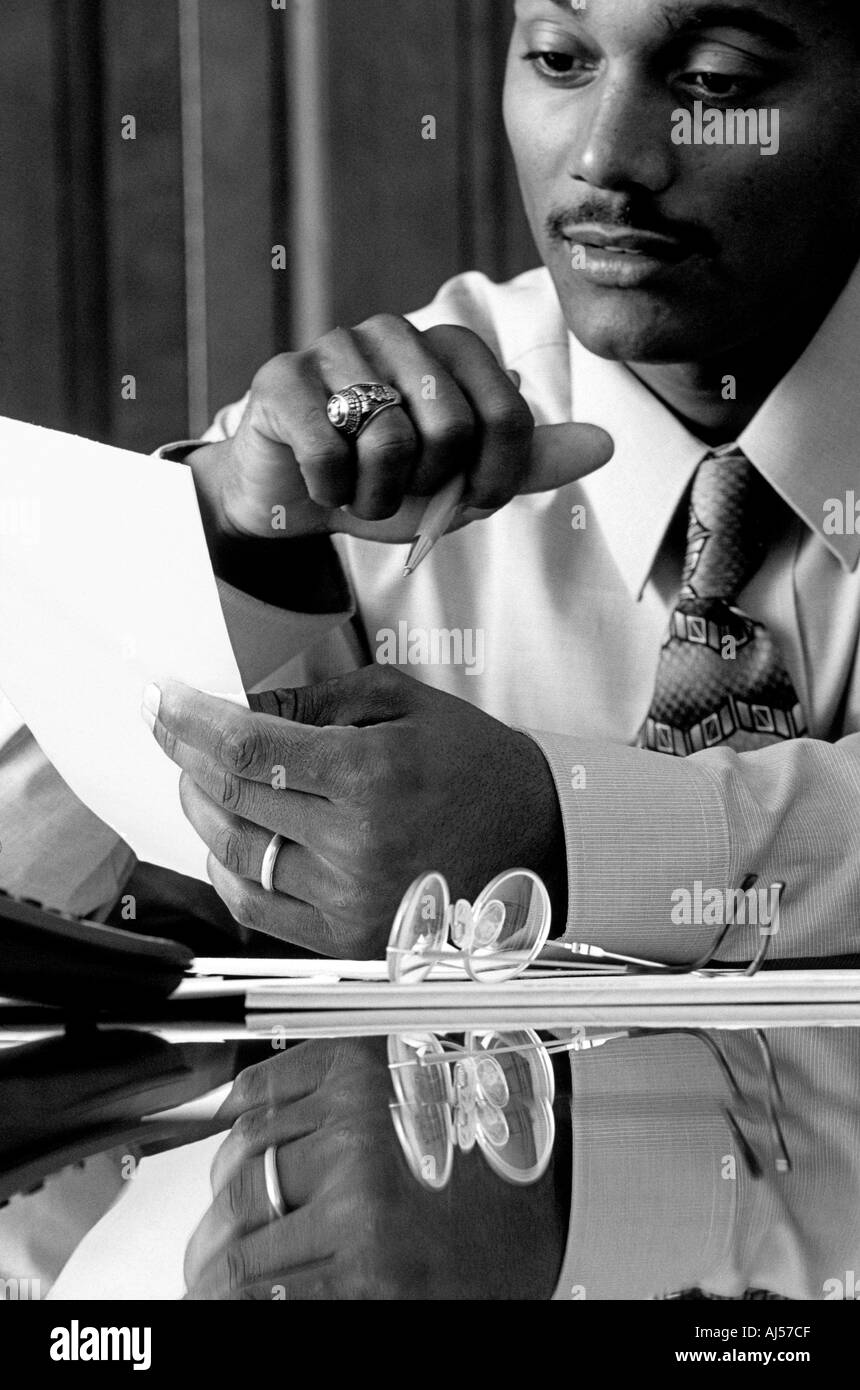 Black and white Latino male executive at desk studying paperwork Stock ...