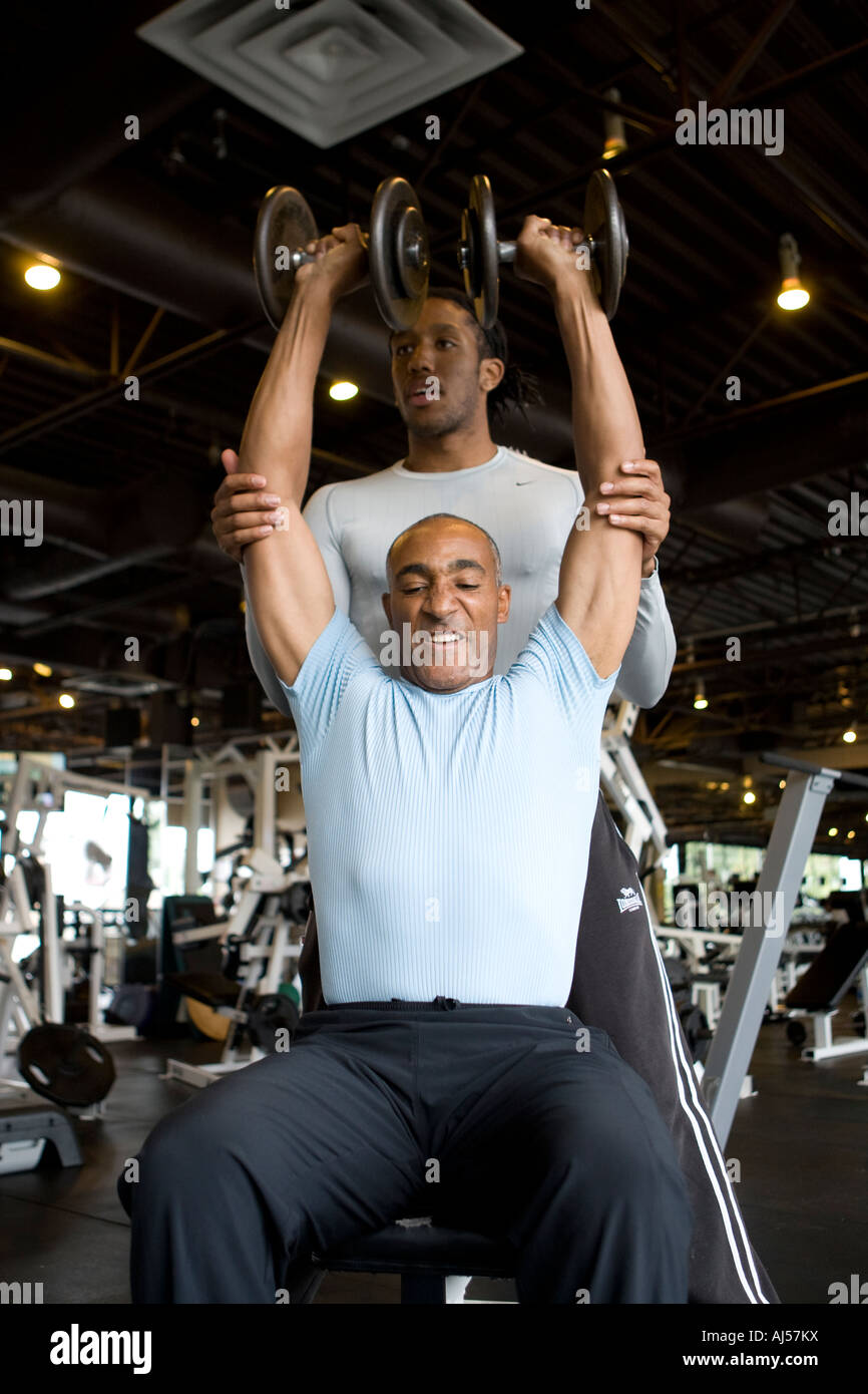 two 2 fit fitness males men exercising in a gym shoulder workout spot ...