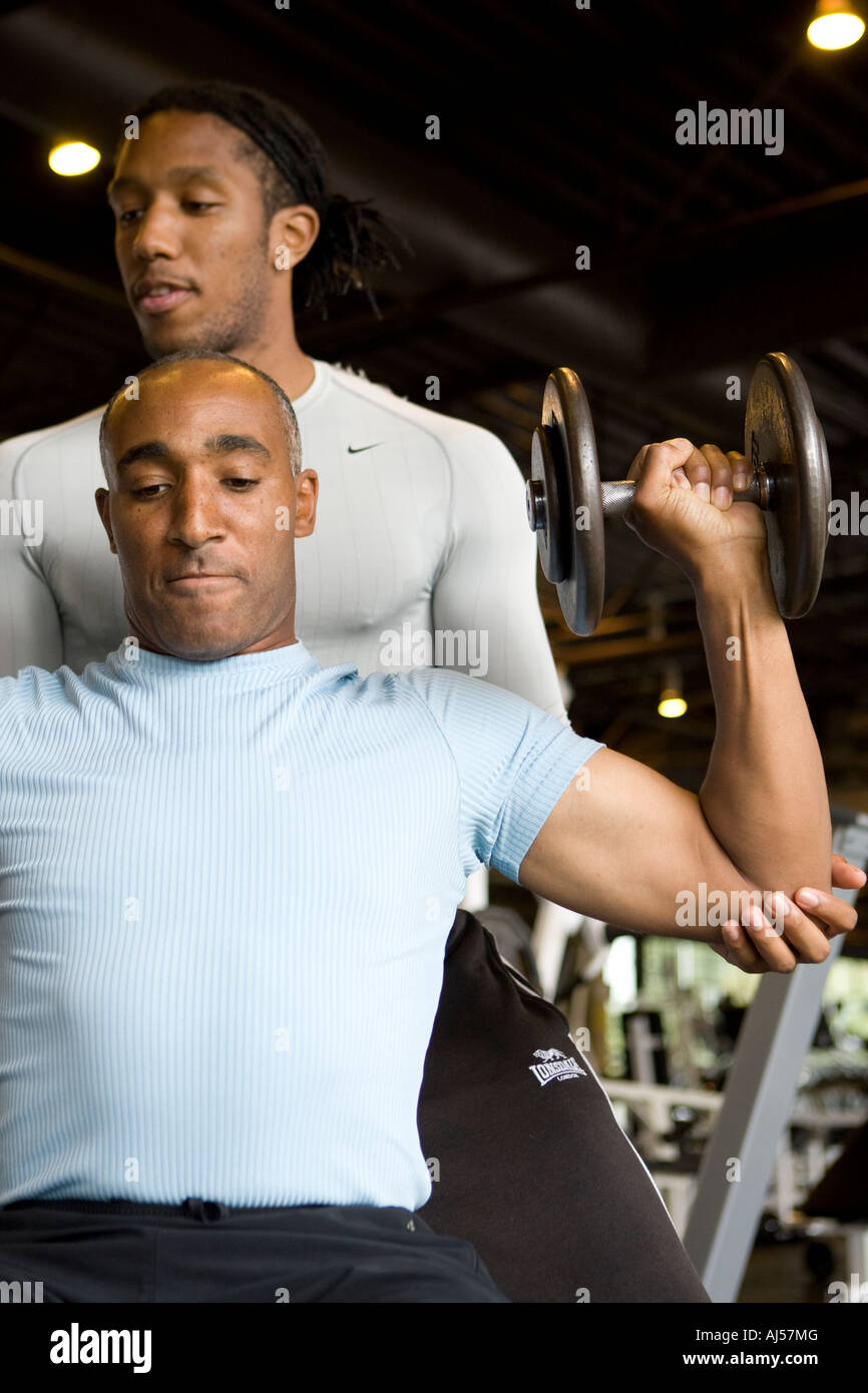 two 2 fit fitness males men exercising in a gym shoulder workout spot ...