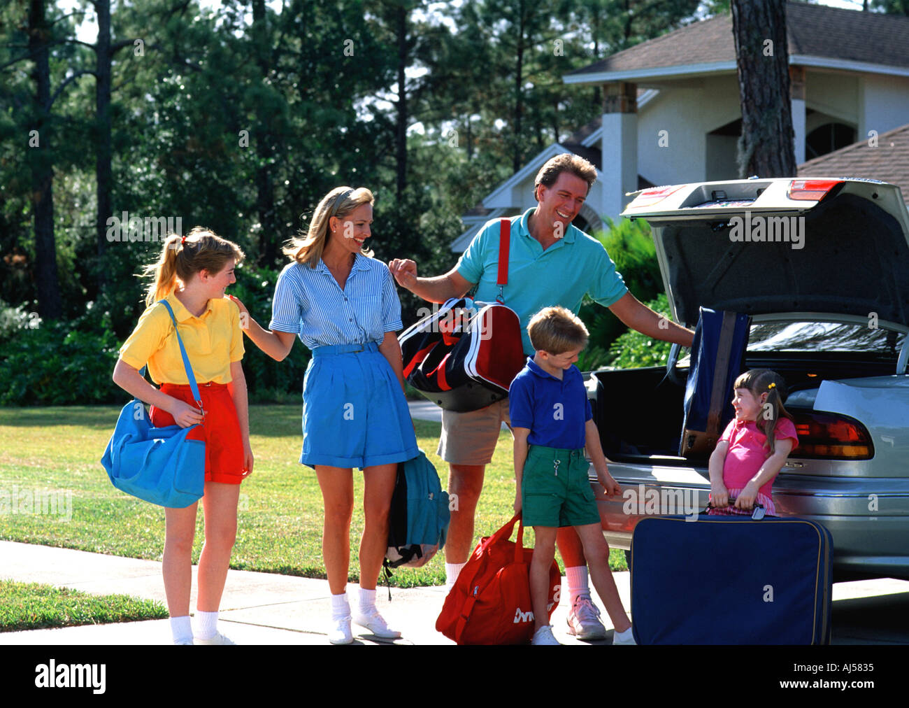 Family in yard packing car with suitcases for vacation Stock Photo - Alamy
