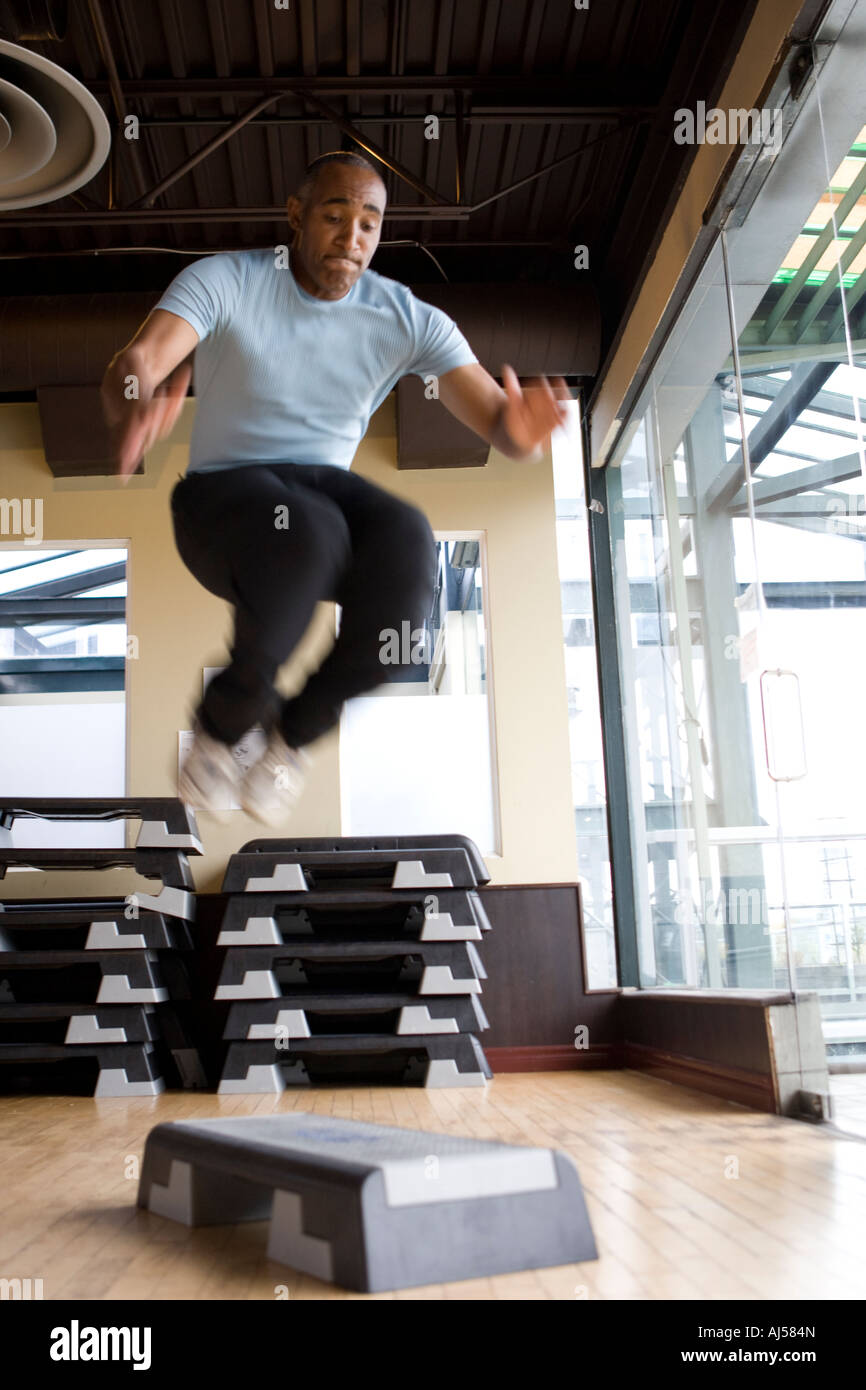 fit fitness male man girl exercising in a gym jump step workout Stock ...