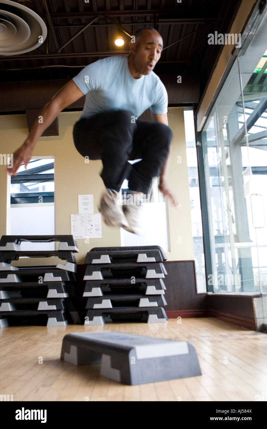 fit fitness male man girl exercising in a gym jump step workout Stock ...