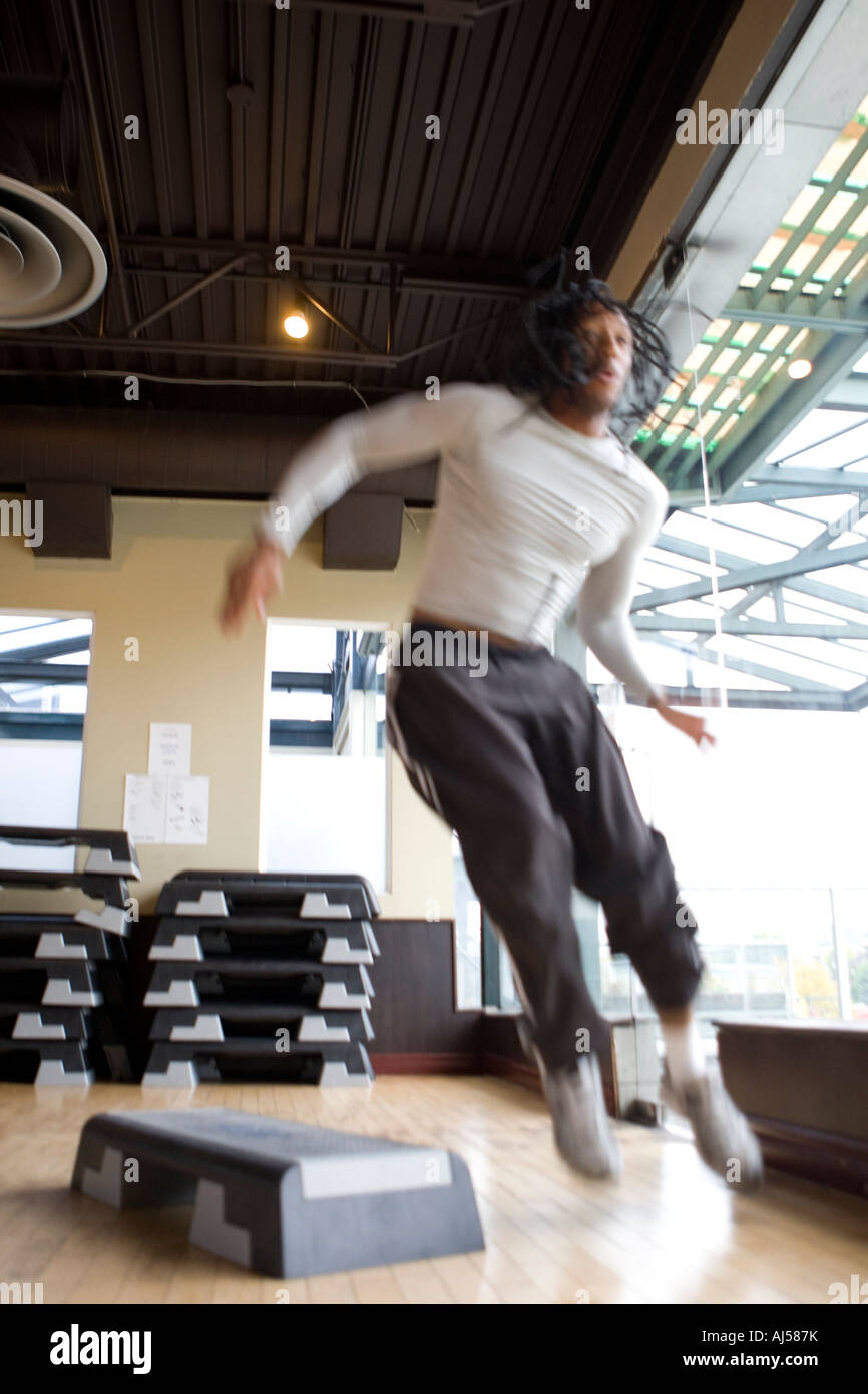 fit fitness male man girl exercising in a gym jump step workout Stock ...