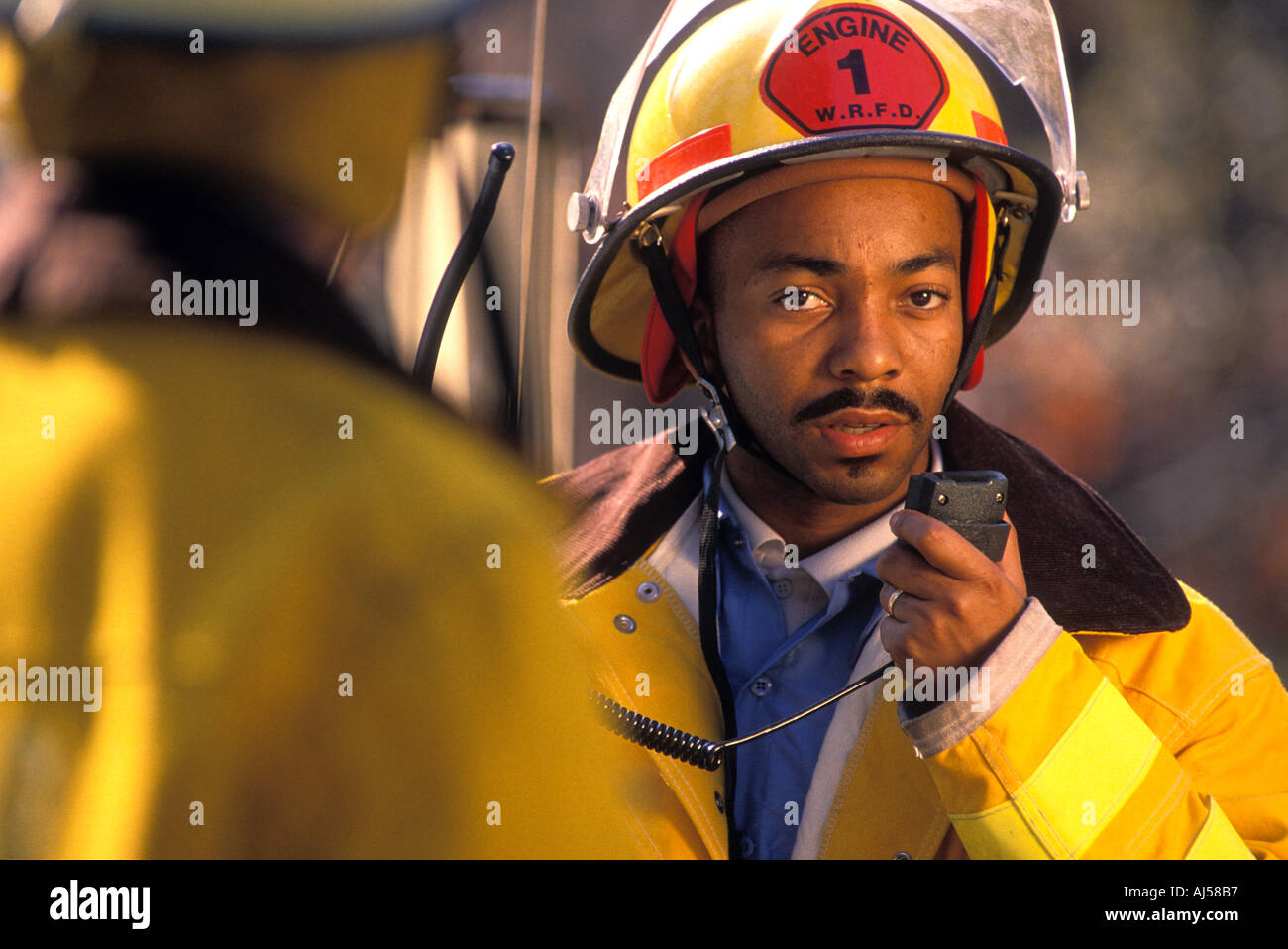 African American fire fighter calling control center on radio Stock ...