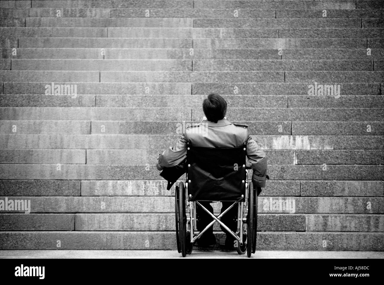 Black and white handicapped man in wheelchair confronting a staircase ...