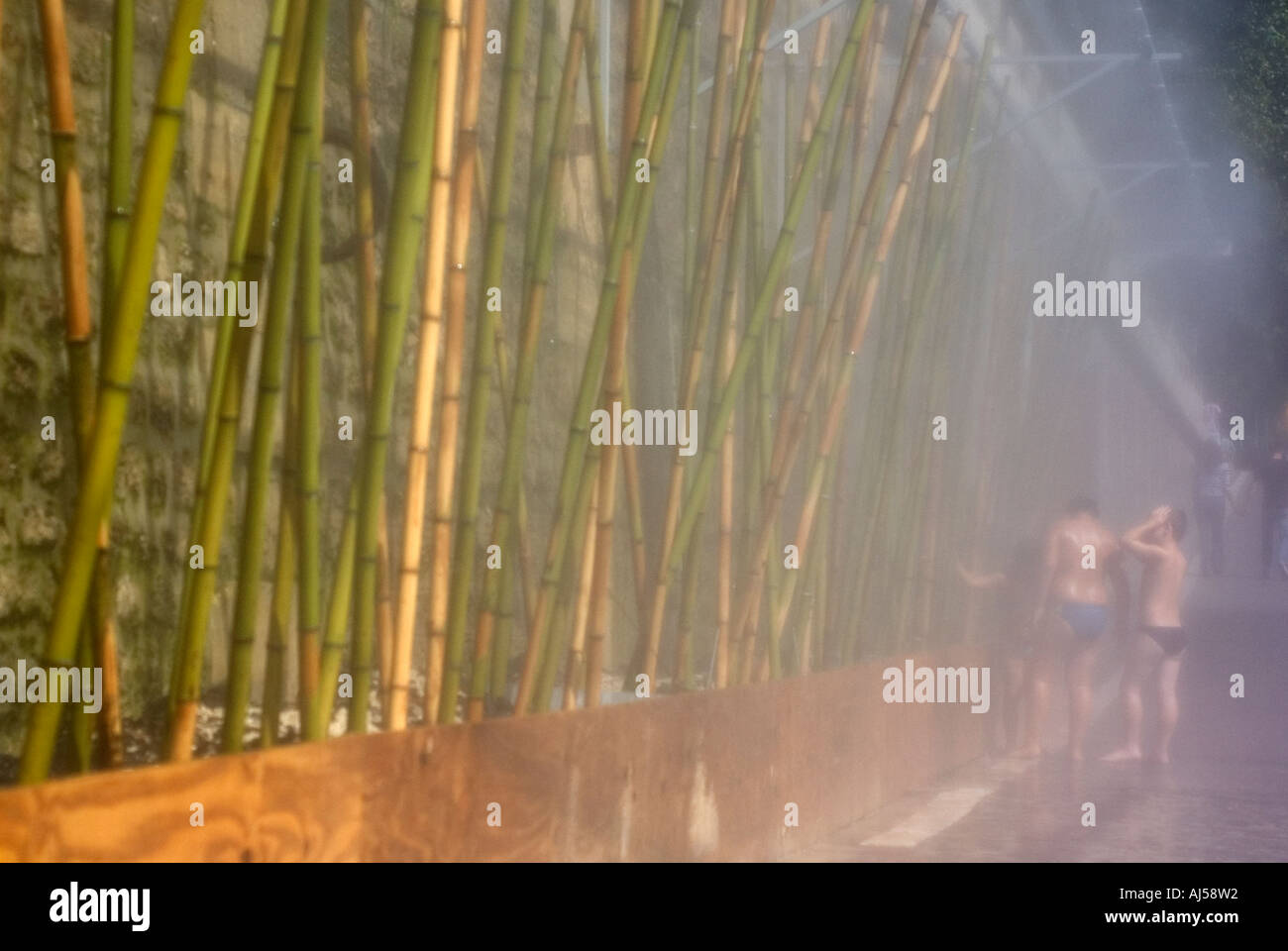 Children playing under sprayed mist during a summer heatwave, during ...