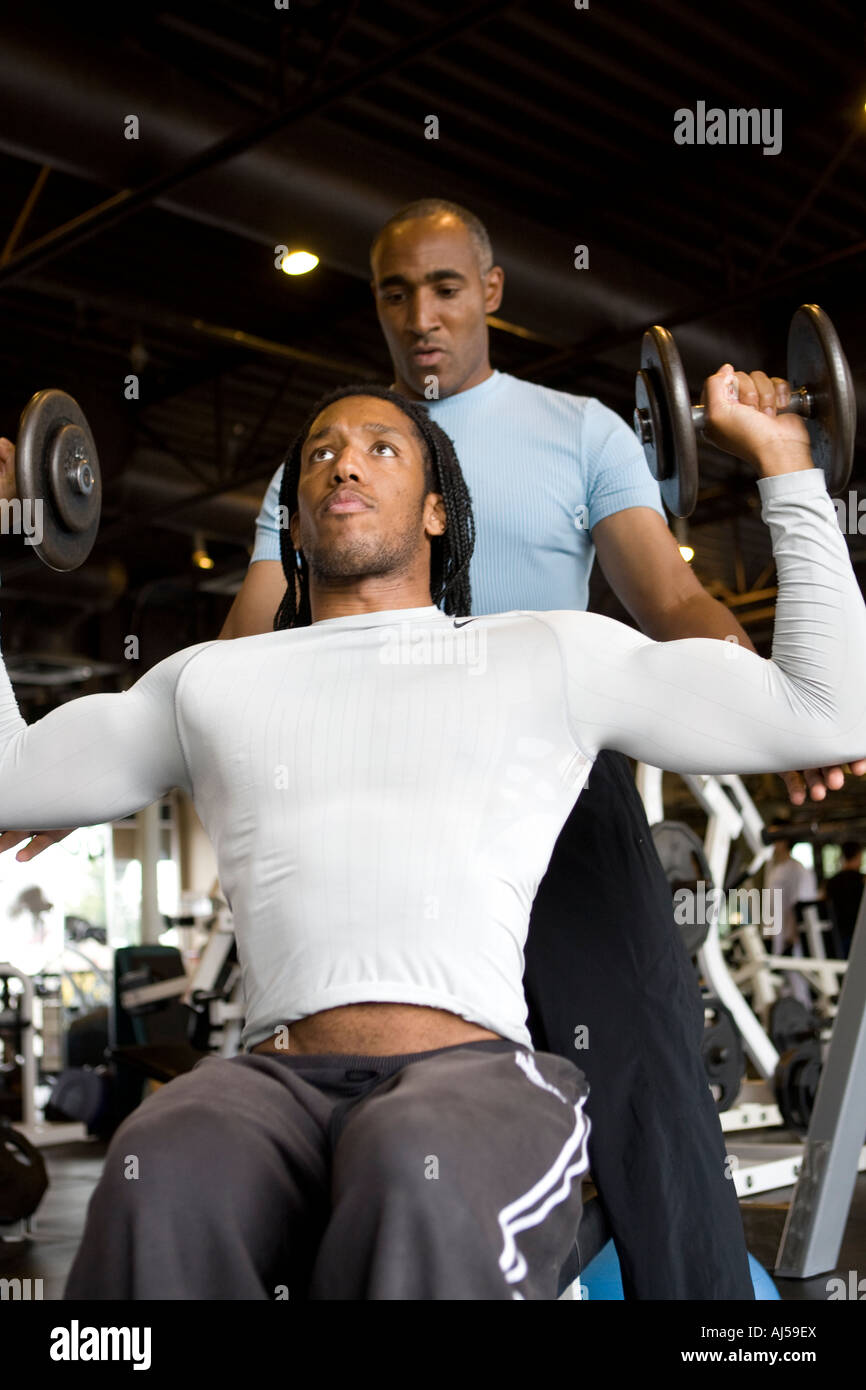 two 2 fit fitness males men exercising in a gym shoulder workout spot ...