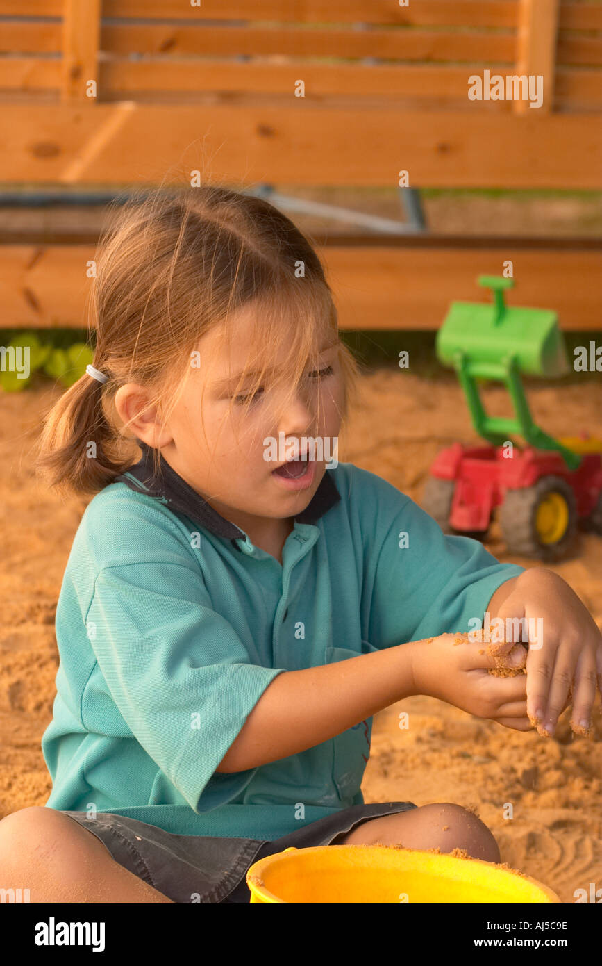 young girl playing in sandpit Stock Photo - Alamy