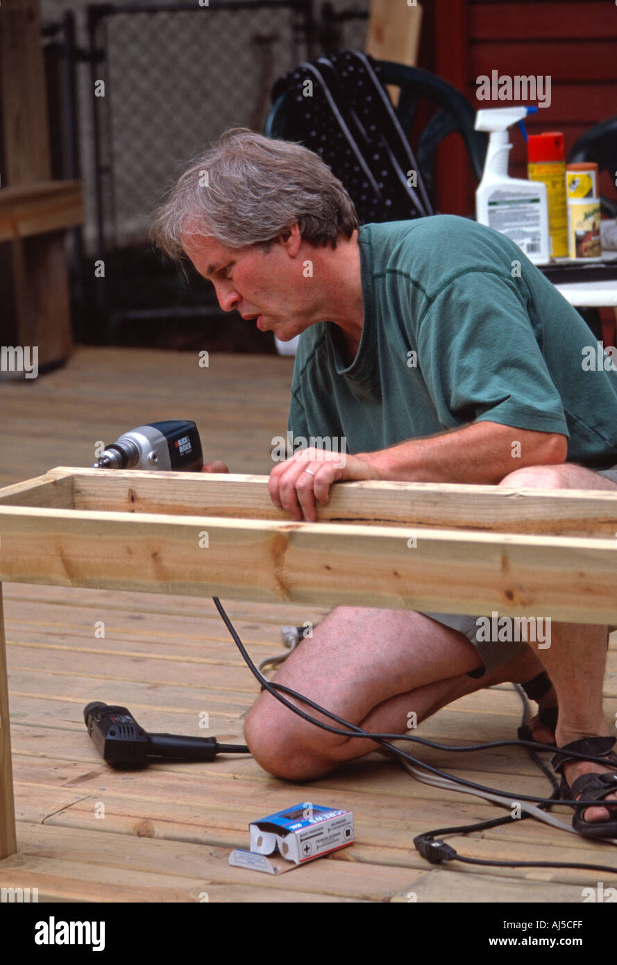 Man at work building deck using power drill Stock Photo - Alamy