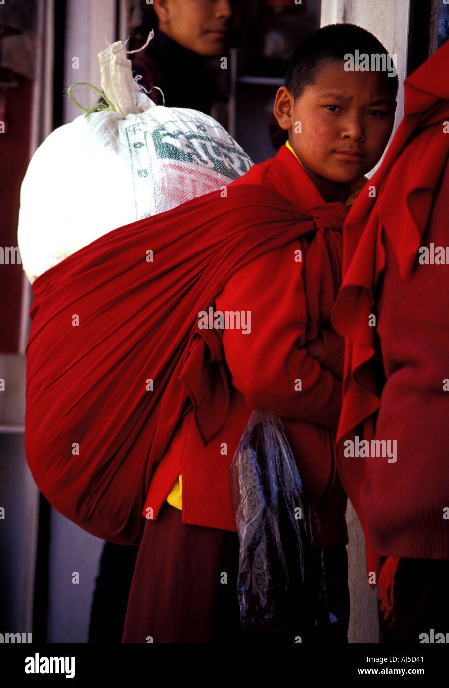 Nepal Kathmandu A young novice monk carries a heavy load of rice Stock ...