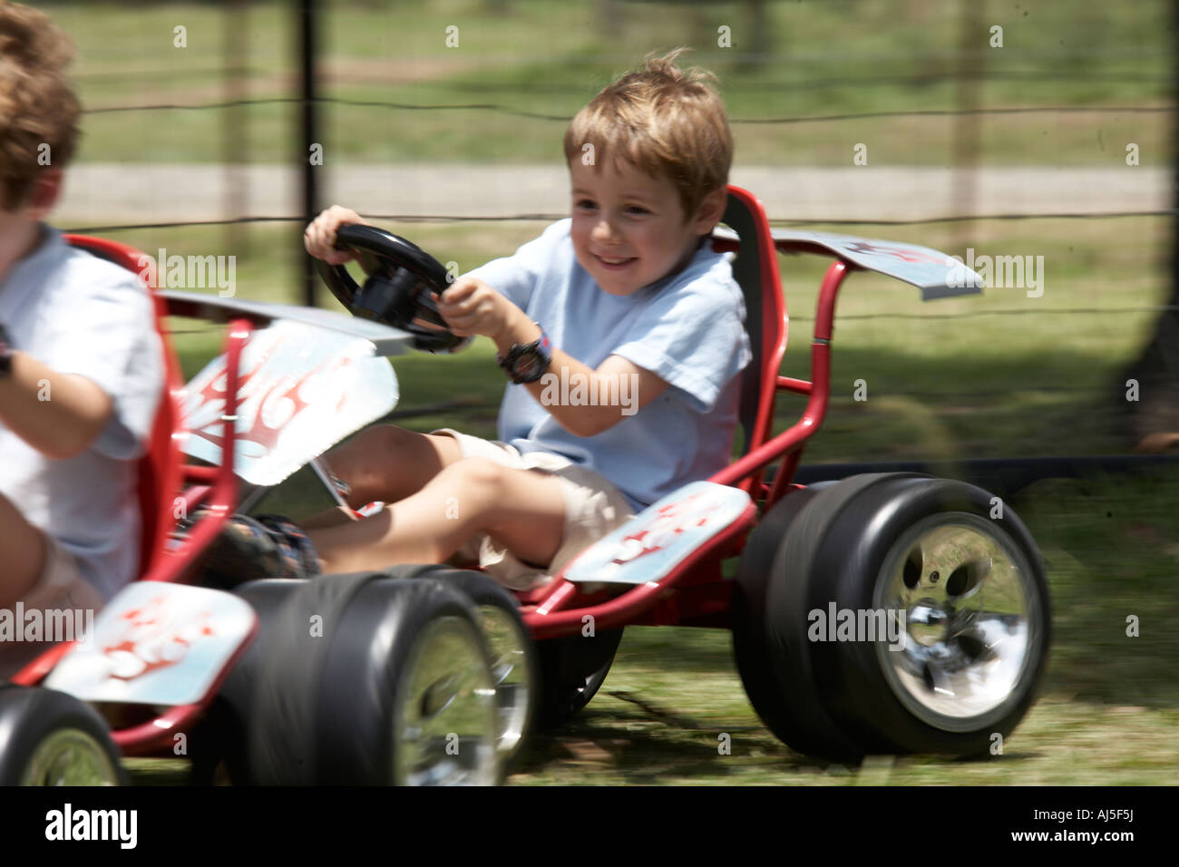 Young boy child driving racing Go Kart outdoors with motion blur in ...
