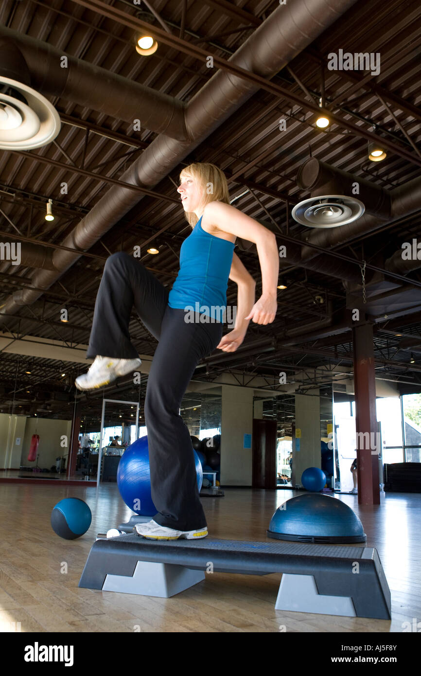fit fitness female girl exercising in a gym. arm shoulder aerobic step ...
