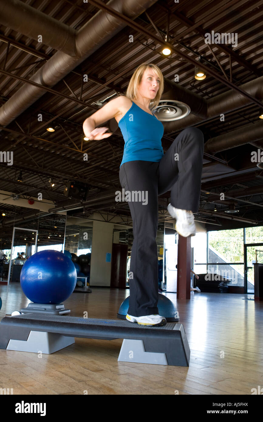 fit fitness female girl exercising in a gym. arm shoulder aerobic step ...