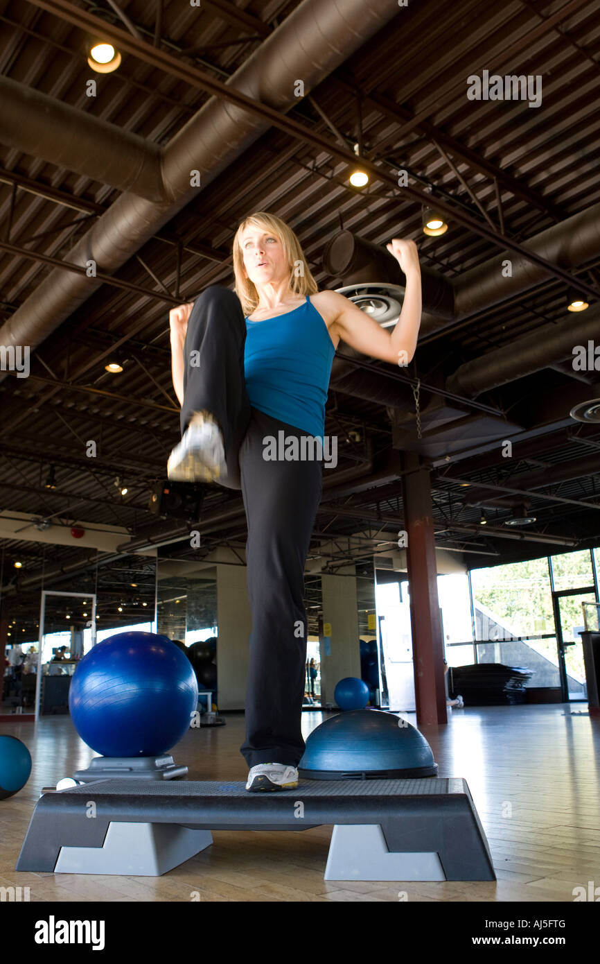 fit fitness female girl exercising in a gym. arm shoulder aerobic step ...
