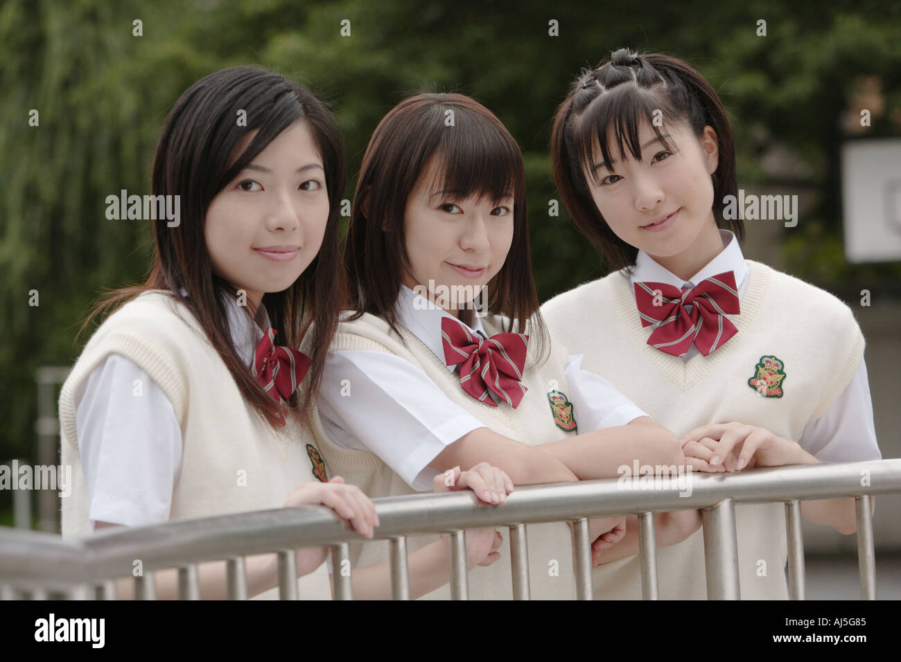 Three high school girls leaning on railing Stock Photo - Alamy
