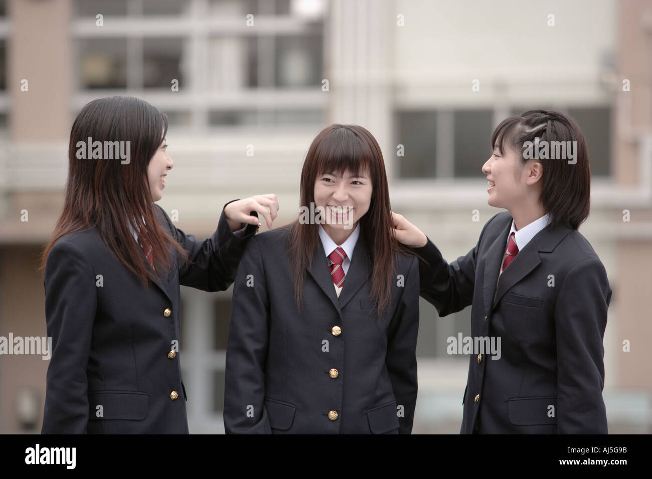 Three high school girls talking in schoolyard Stock Photo - Alamy